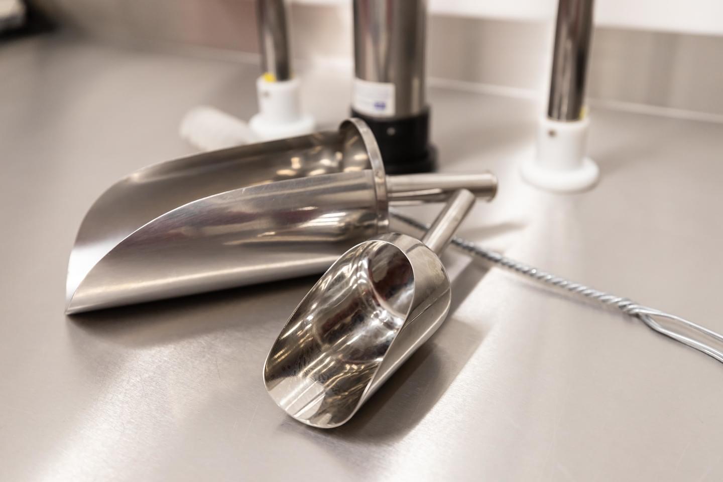 Two different sized metal scoops used for sampling